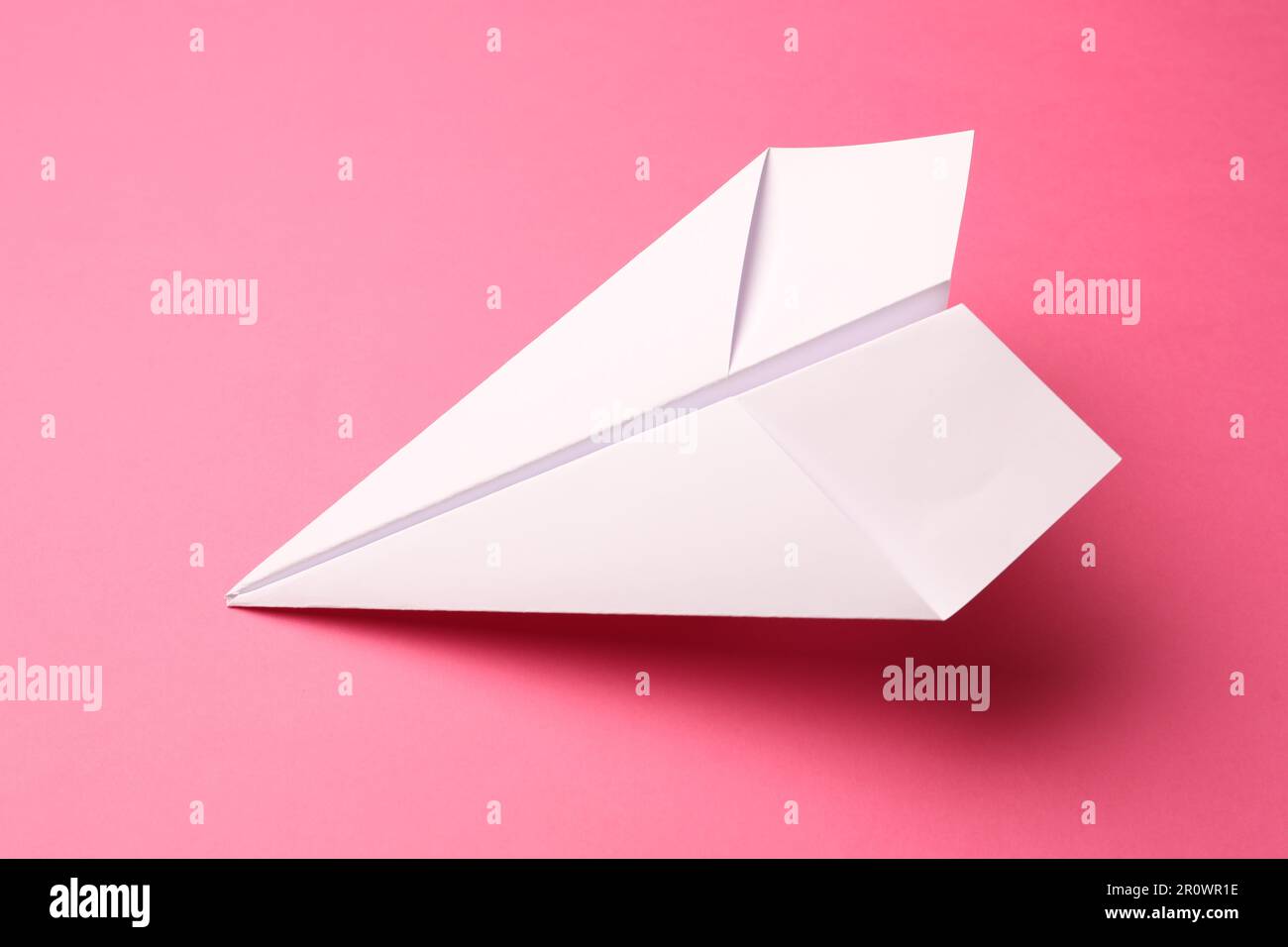 Handmade white paper plane on pink background Stock Photo - Alamy