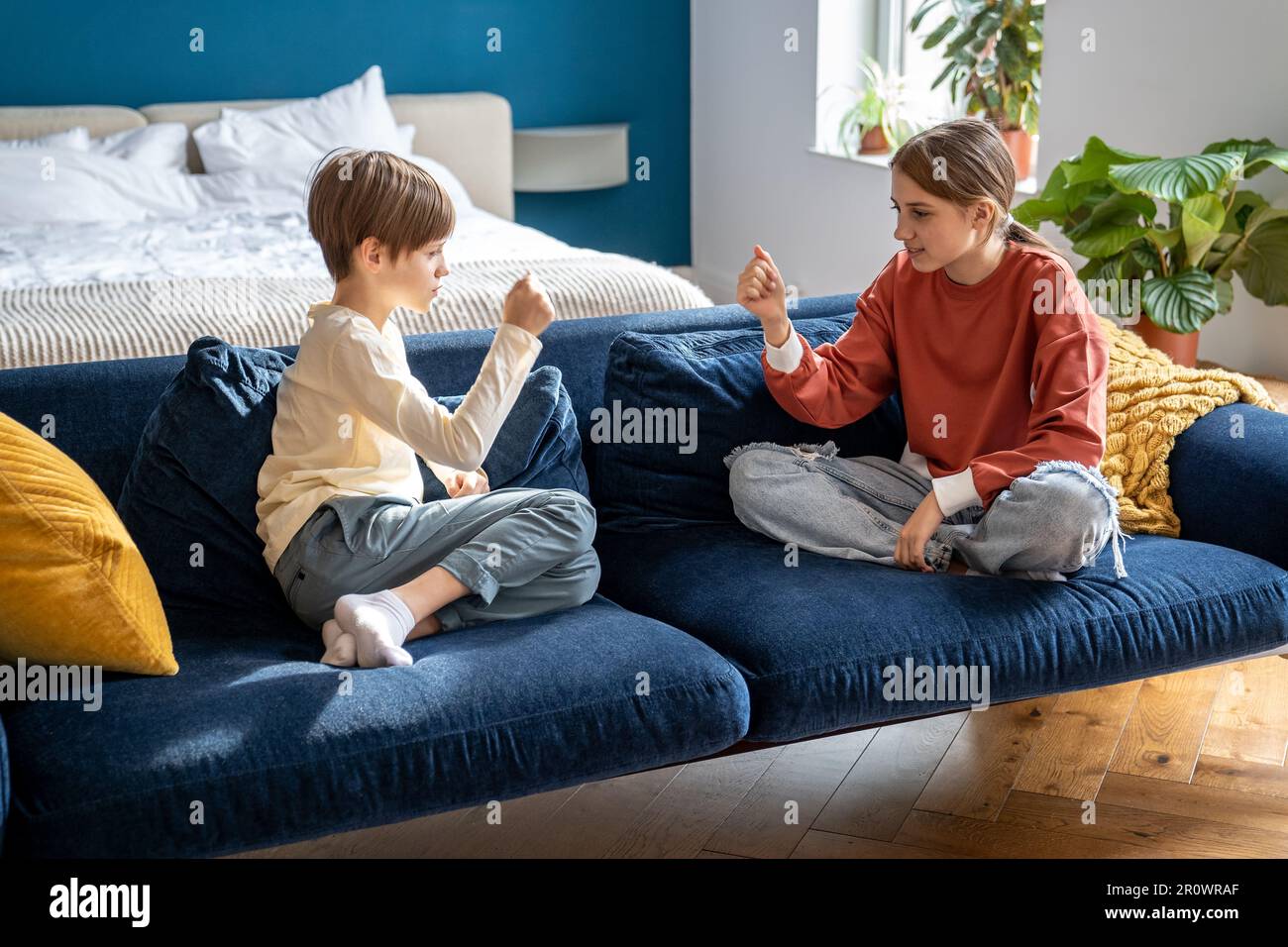 Siblings teen sister brother playing rock paper scissors game sitting ...