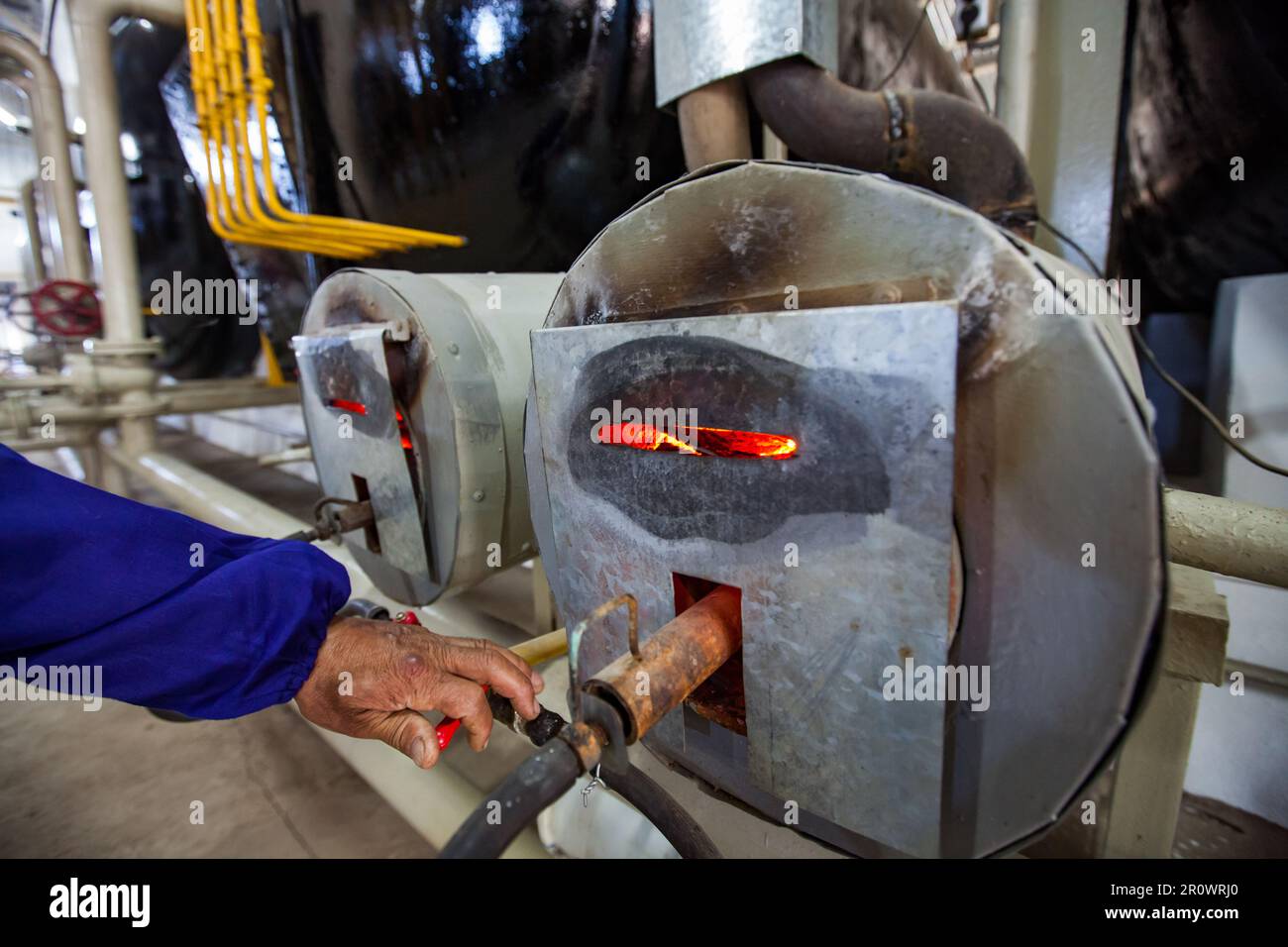 Closeup photo of biogas plant furnace flame and operator's hand Stock ...