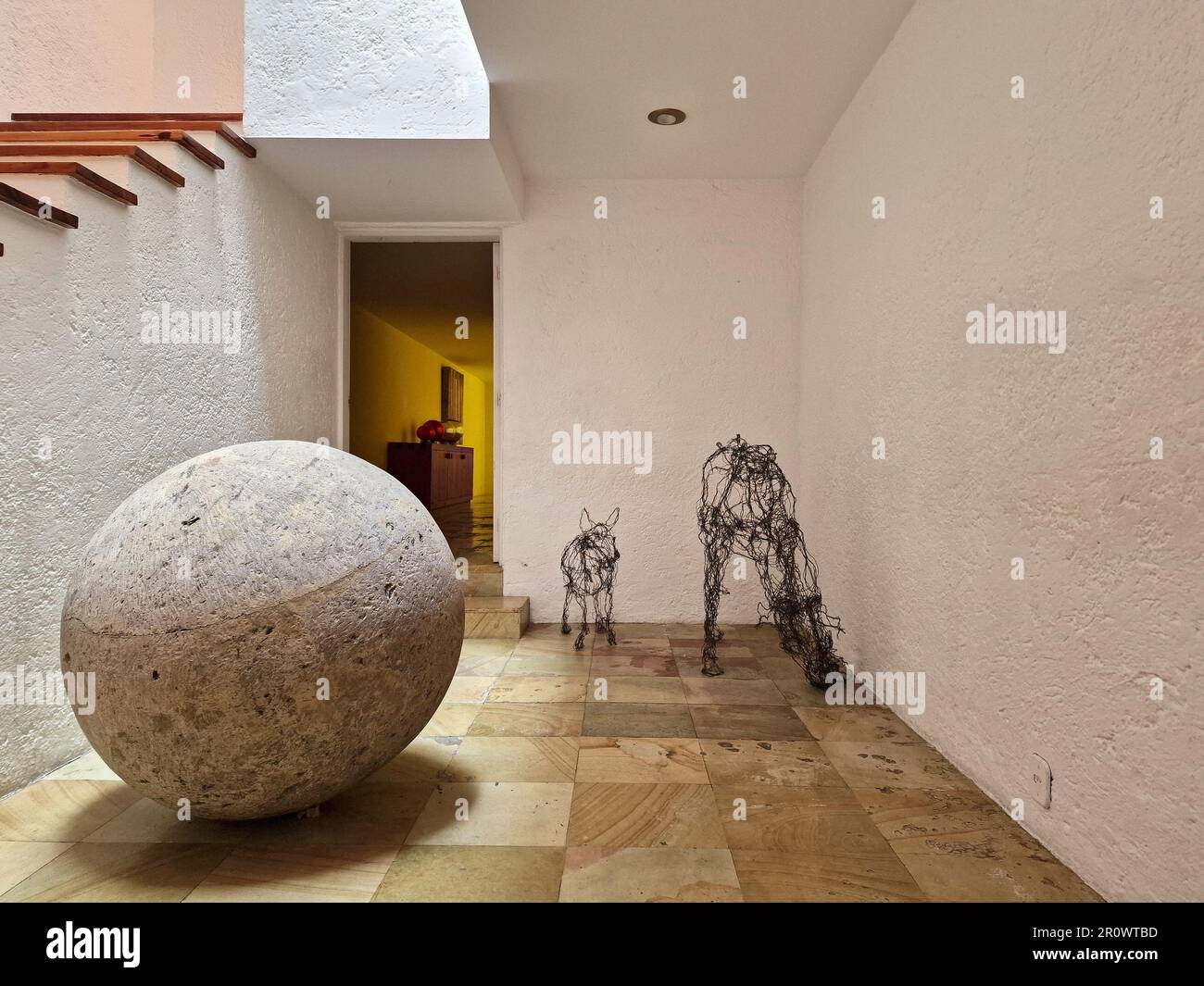 A room with modern sculptures: a stone sphere, and animal sculptures ...
