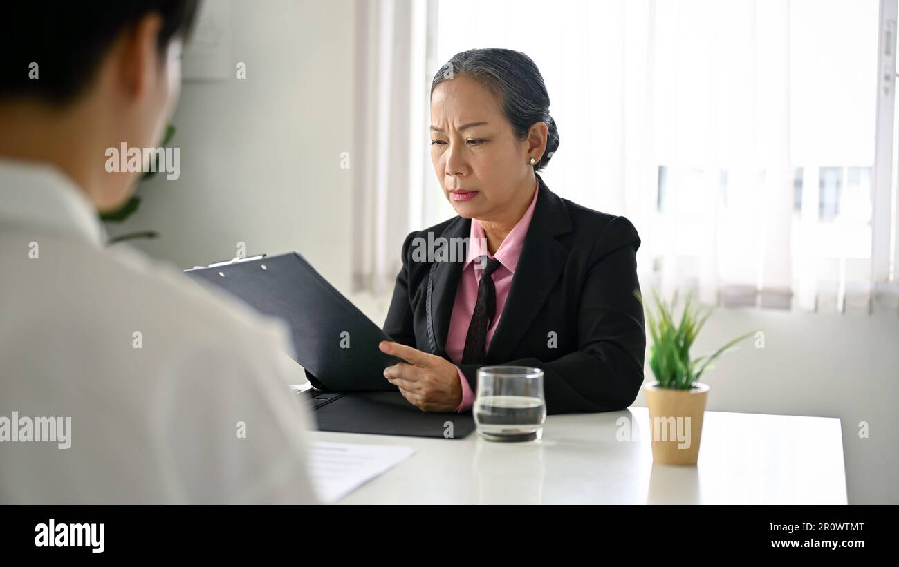 Stressed and focused senior Asian businesswoman or female HR manager ...