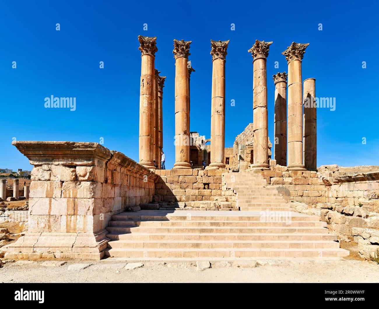 Ancient Roman colonnade street with stone pavement and clear blue sky ...