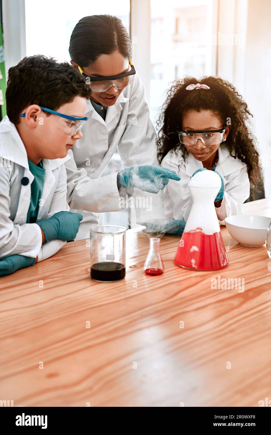Children, science teacher and experiment with beaker for learning ...