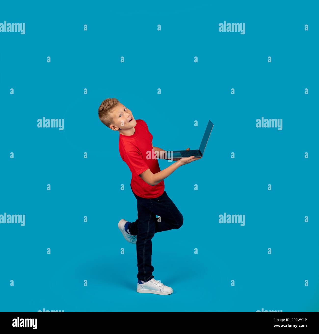 Cheerful Preteen Boy Holding Laptop Computer And Smiling At Camera ...