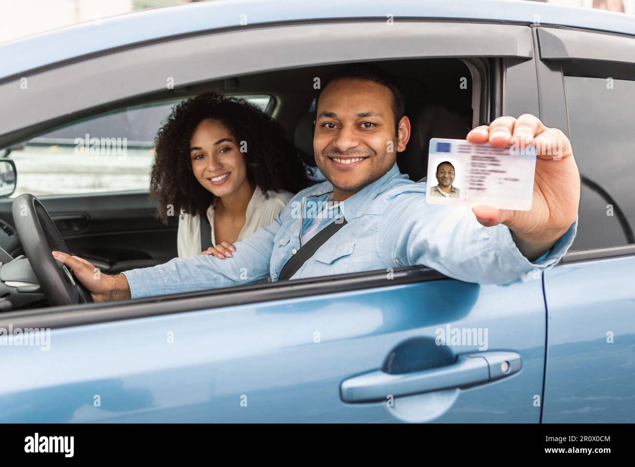Arabic Couple Displaying Driving License Through Window Sitting Inside ...