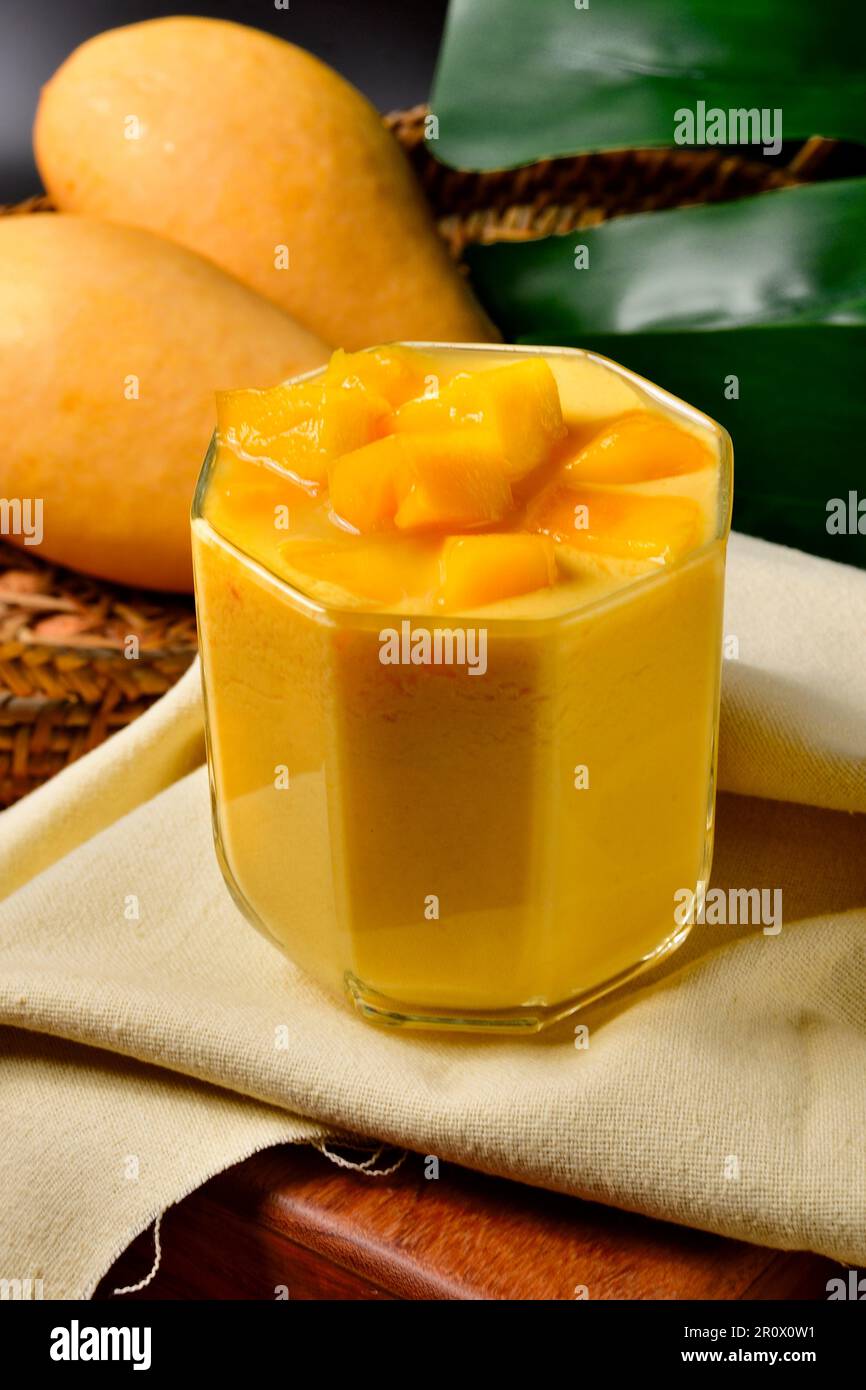 Refreshing Thai mango smoothie on wooden table and mangoes.Barracuda ...