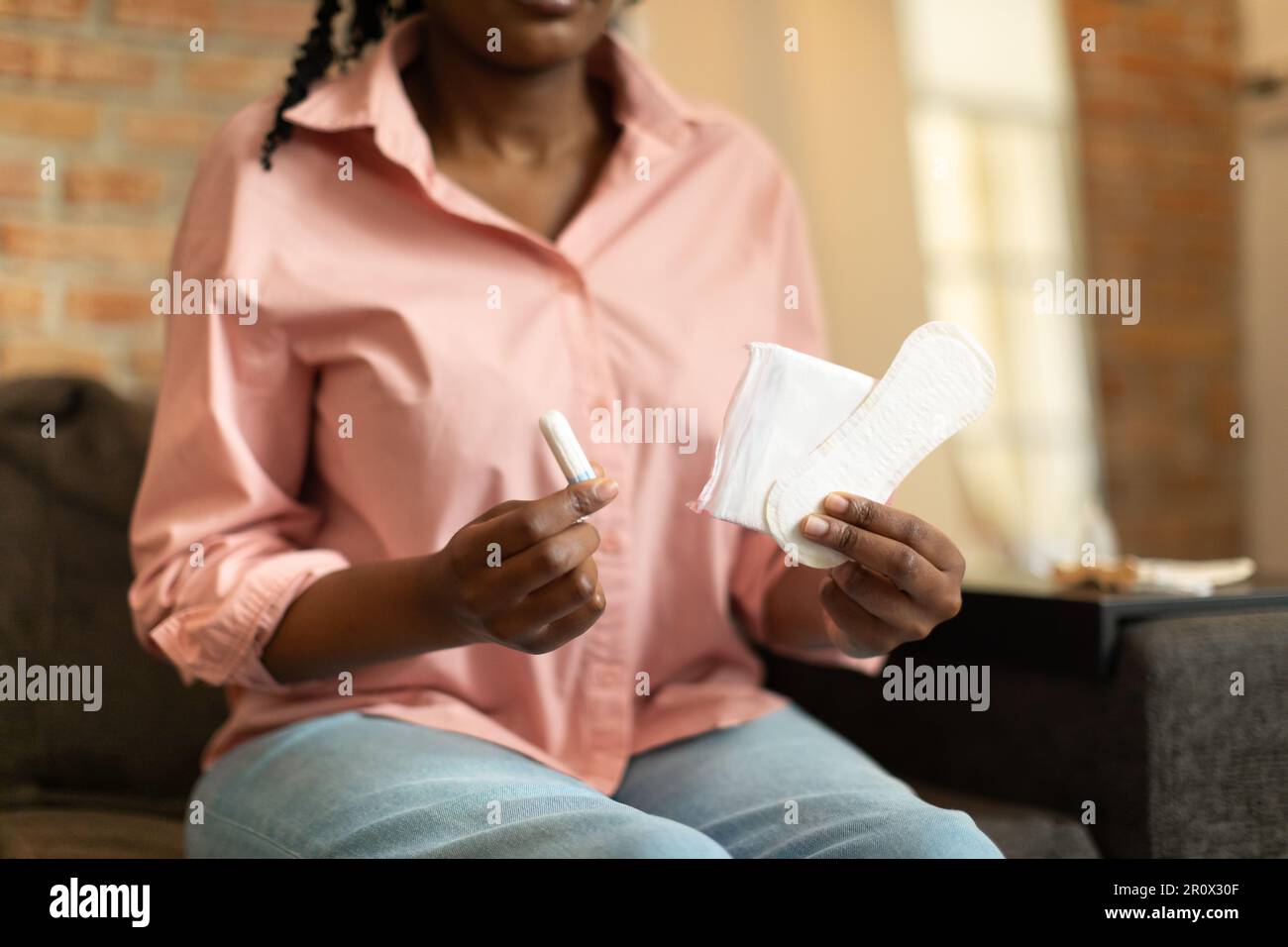 Female period and intimate hygiene. Young black woman holding tampon vs ...
