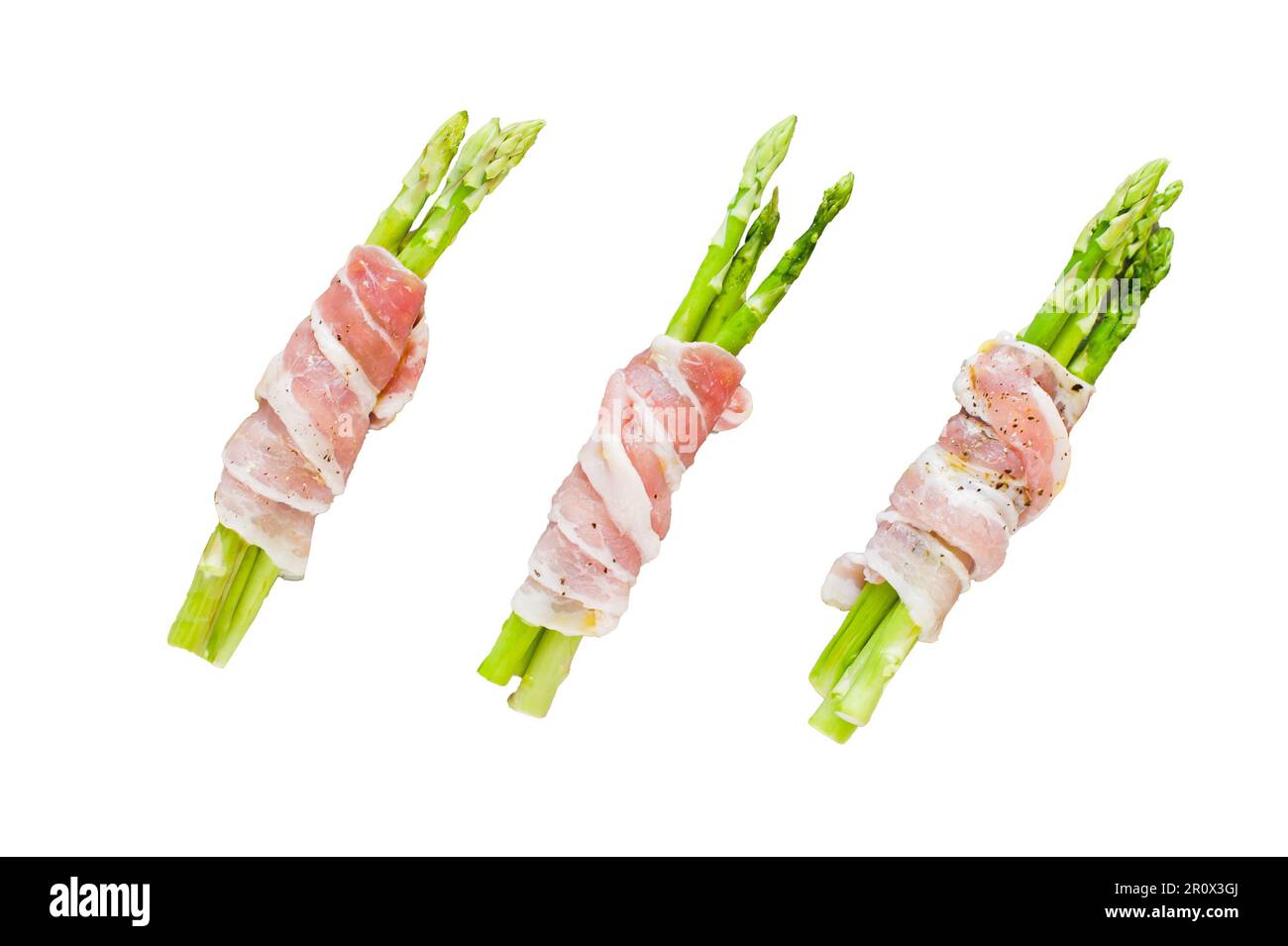 Mini asparagus in bacon on a baking sheet. Isolated on white background ...