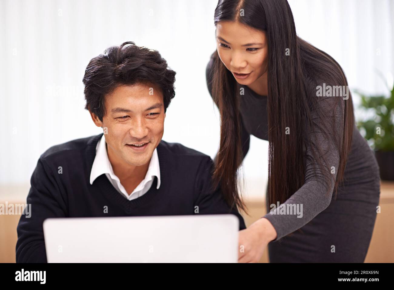 Two minds are better than one. An asian businesswoman giving her male colleague some friendly ...