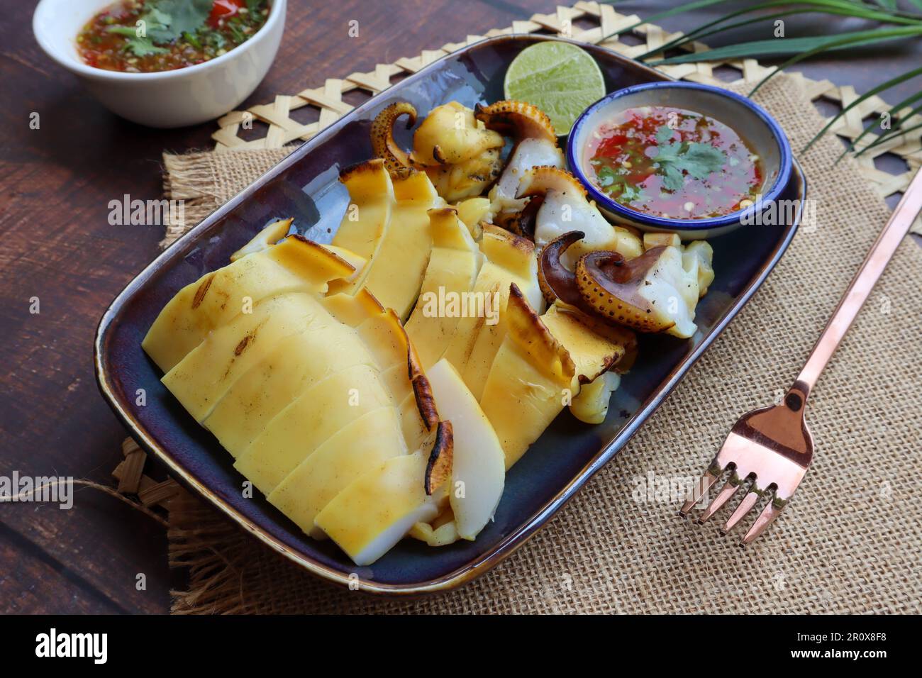 Charcoal grilled squid sliced serving with spicy seafood dipping sauce ...