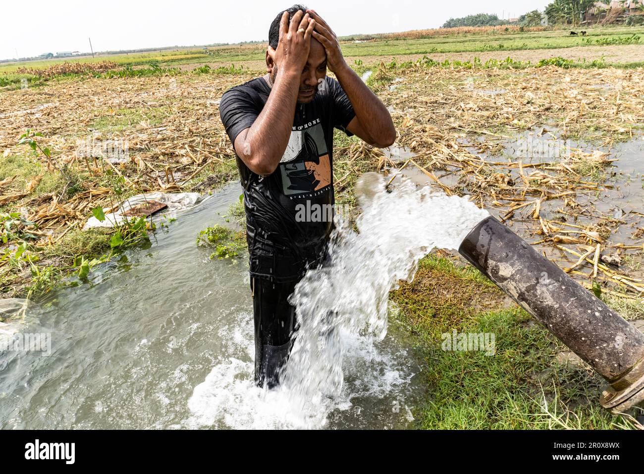 A Handsome guy standing in the outdoors under cool water drops ...