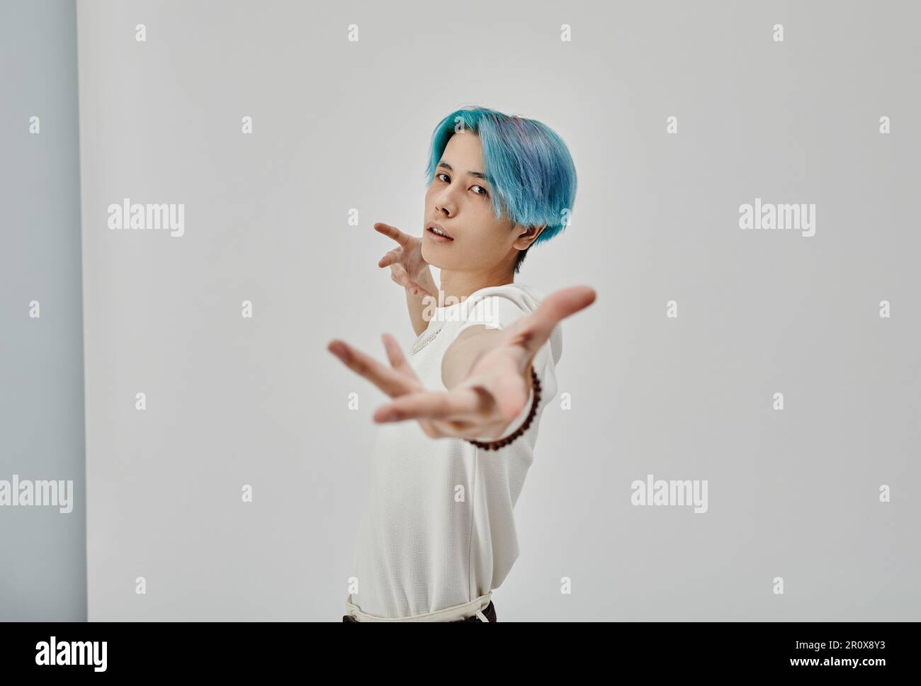 Portrait of young dancer with blue hair dancing alone on white ...