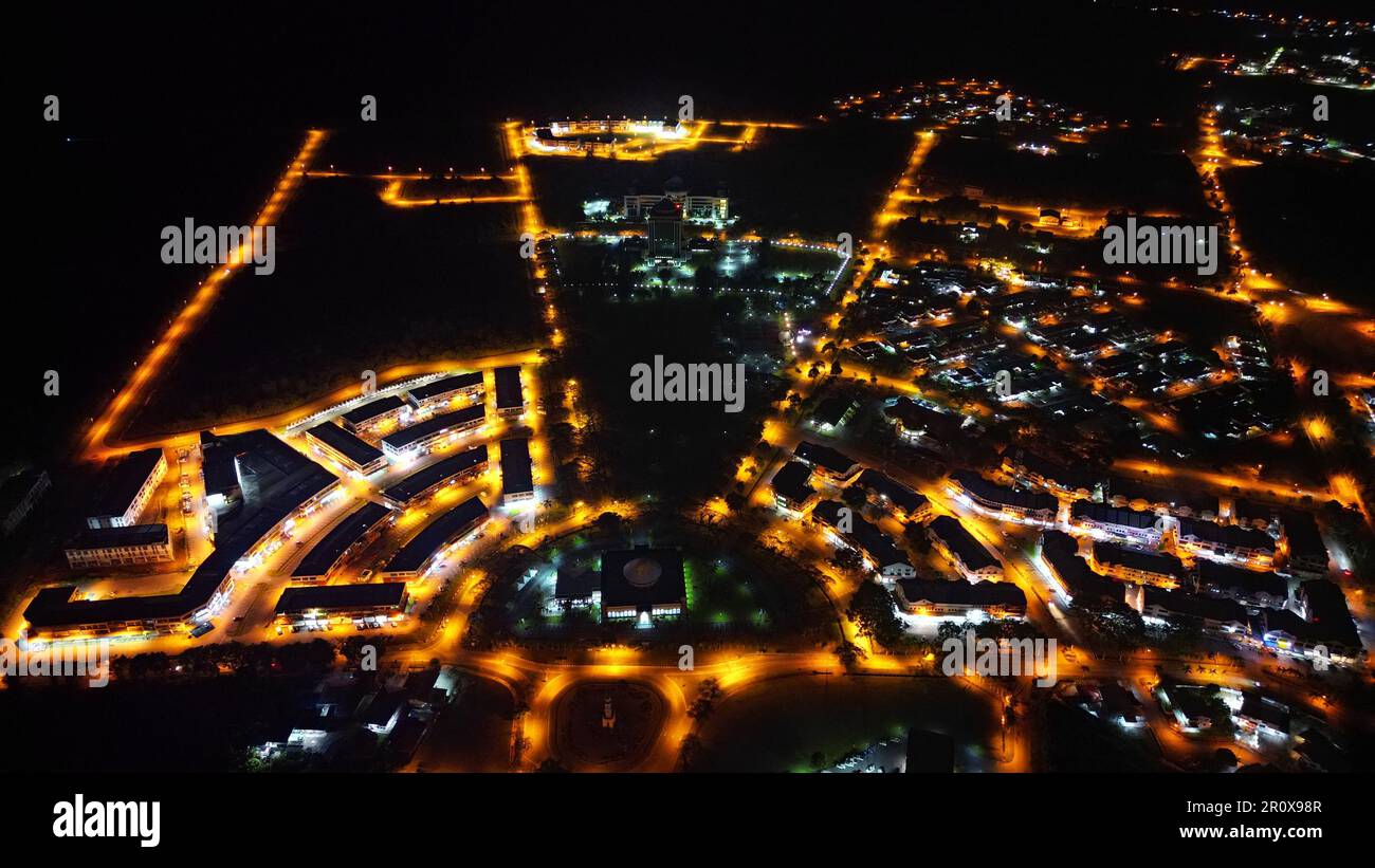 Aerial view of a bustling urban cityscape at night, illuminated by the ...