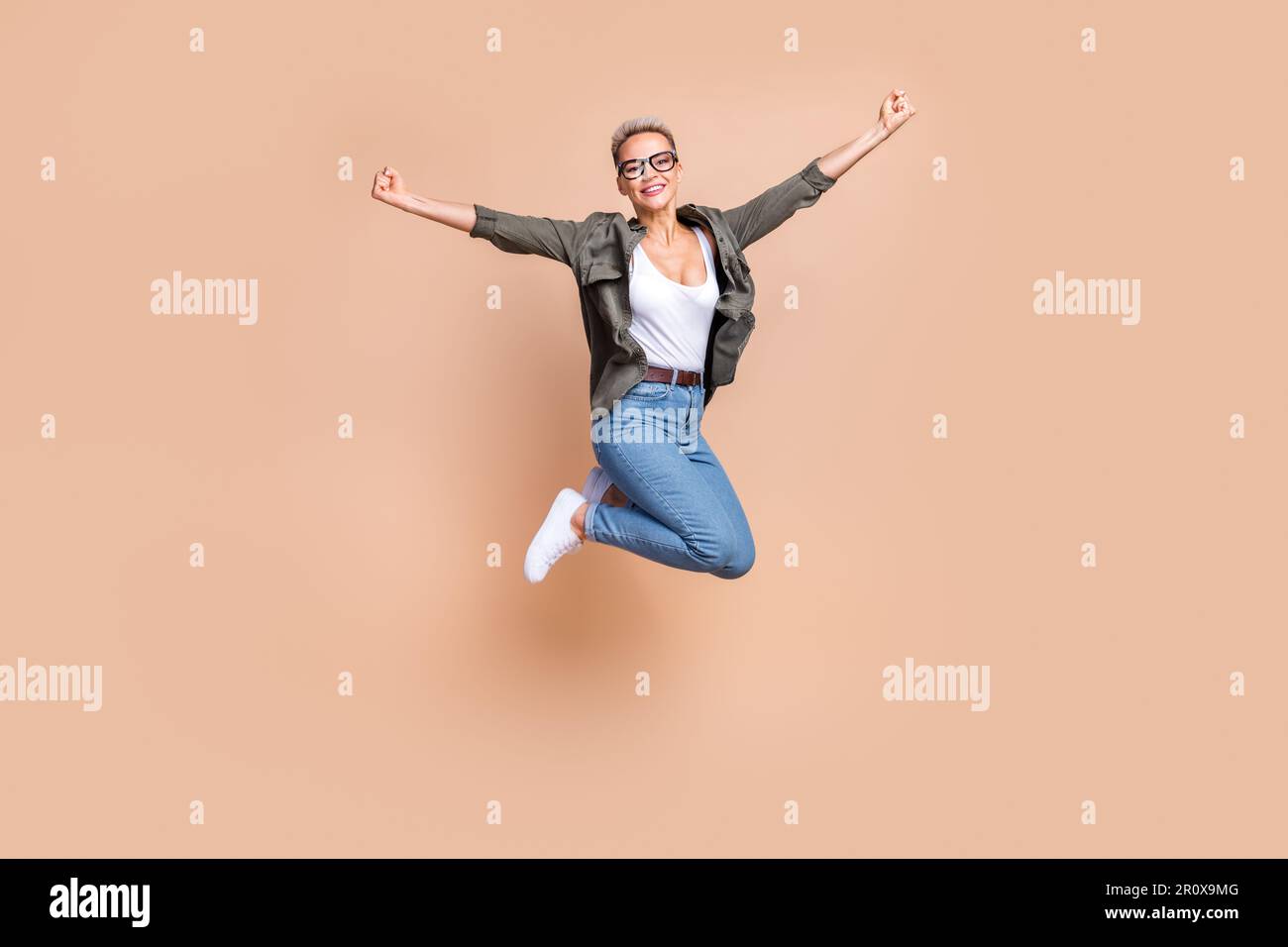 Full length photo of cool lucky woman wear khaki shirt rising fists ...