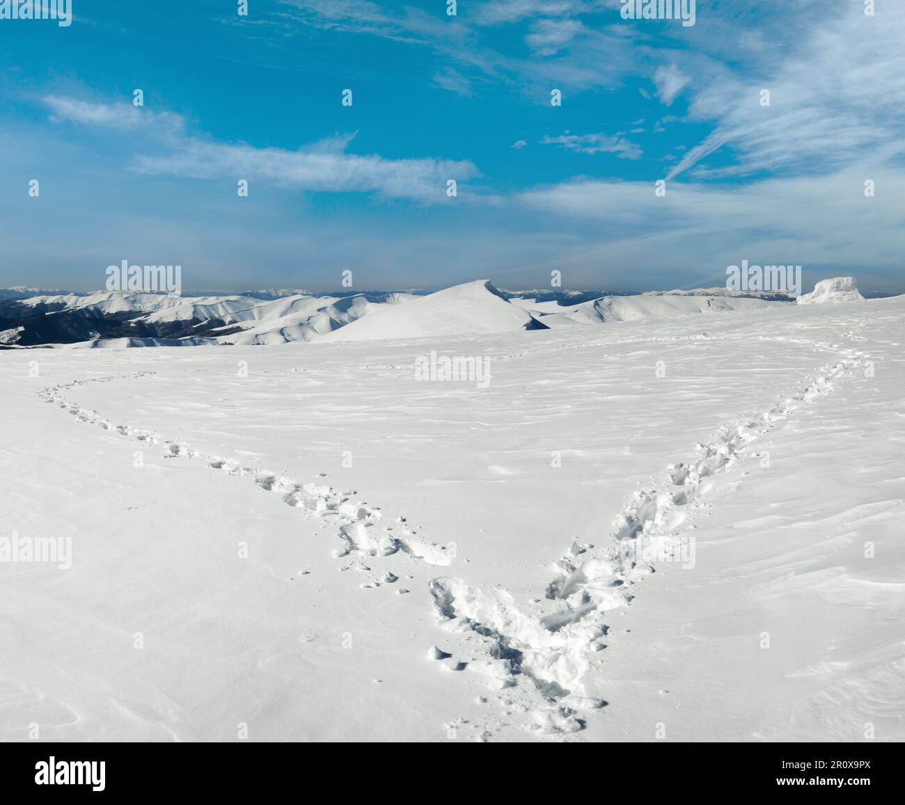 Human footprint form the heart shape on snow-covered mountainside ...