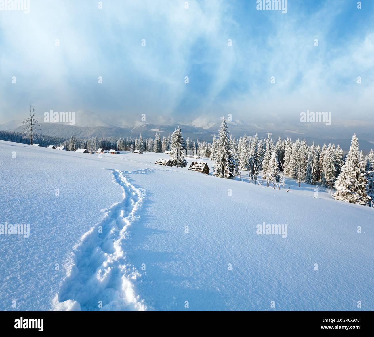 Winter calm mountain landscape with sheds group and mount ridge behind ...