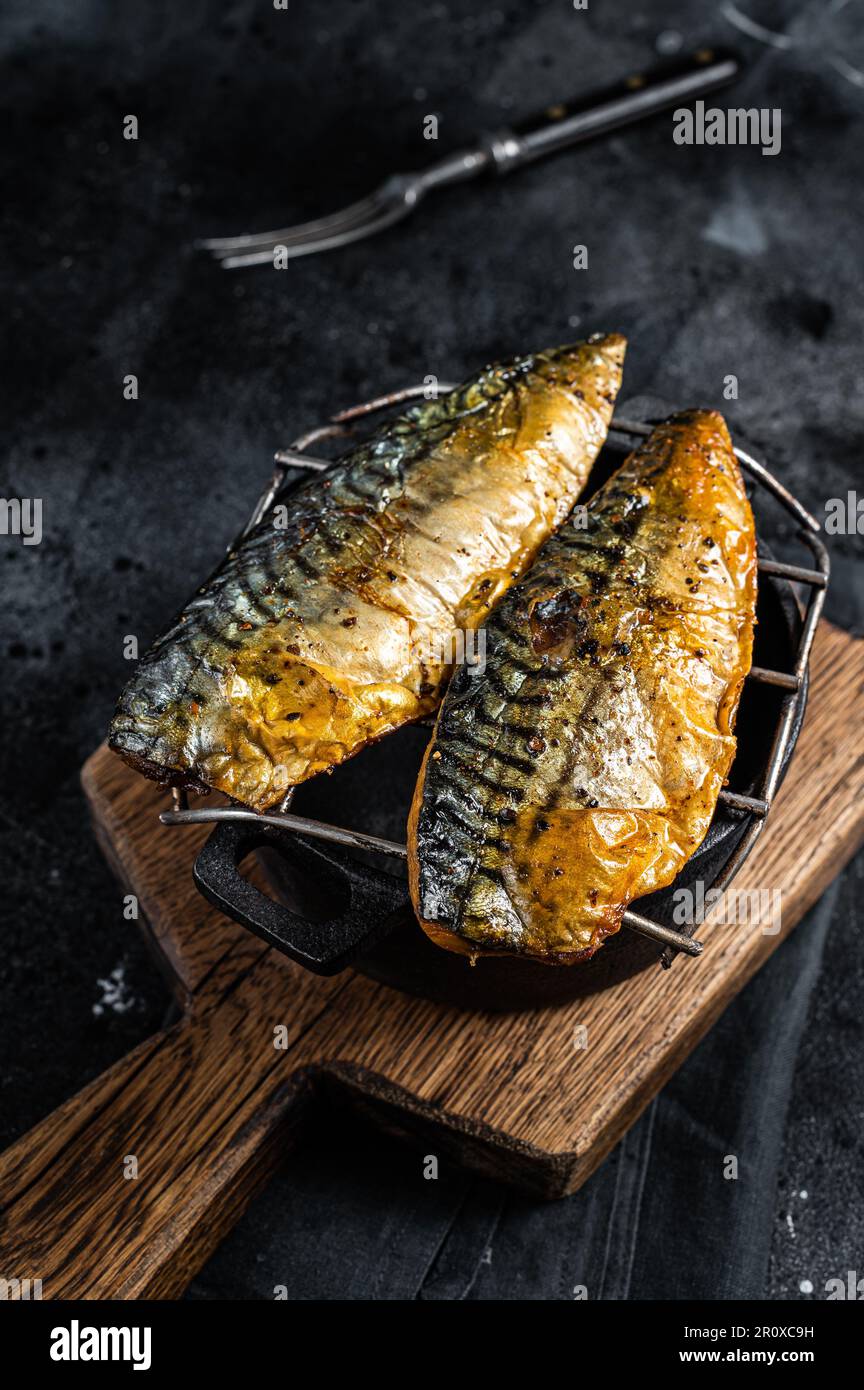 Grilled mackerel fish fillet on a grill. Black background. Top view ...