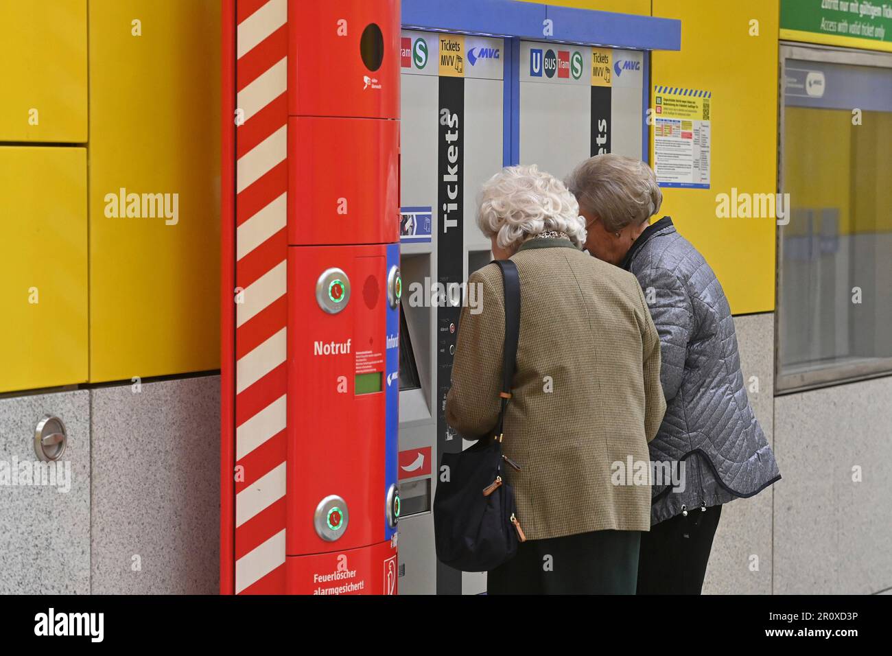 Two seniors, old women are standing in front of a ticket machine from ...