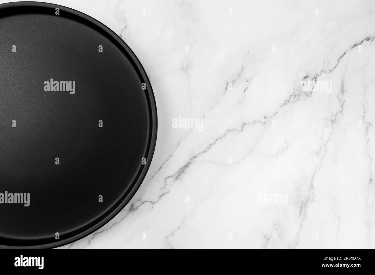 Top view of black plate on white marble background. Food presentation ...