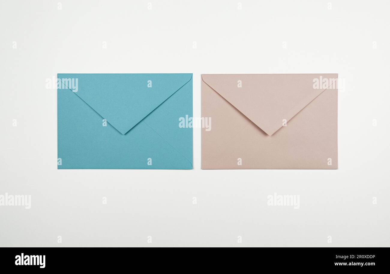 Top view of pink and blue envelopes on white background. Two envelopes ...
