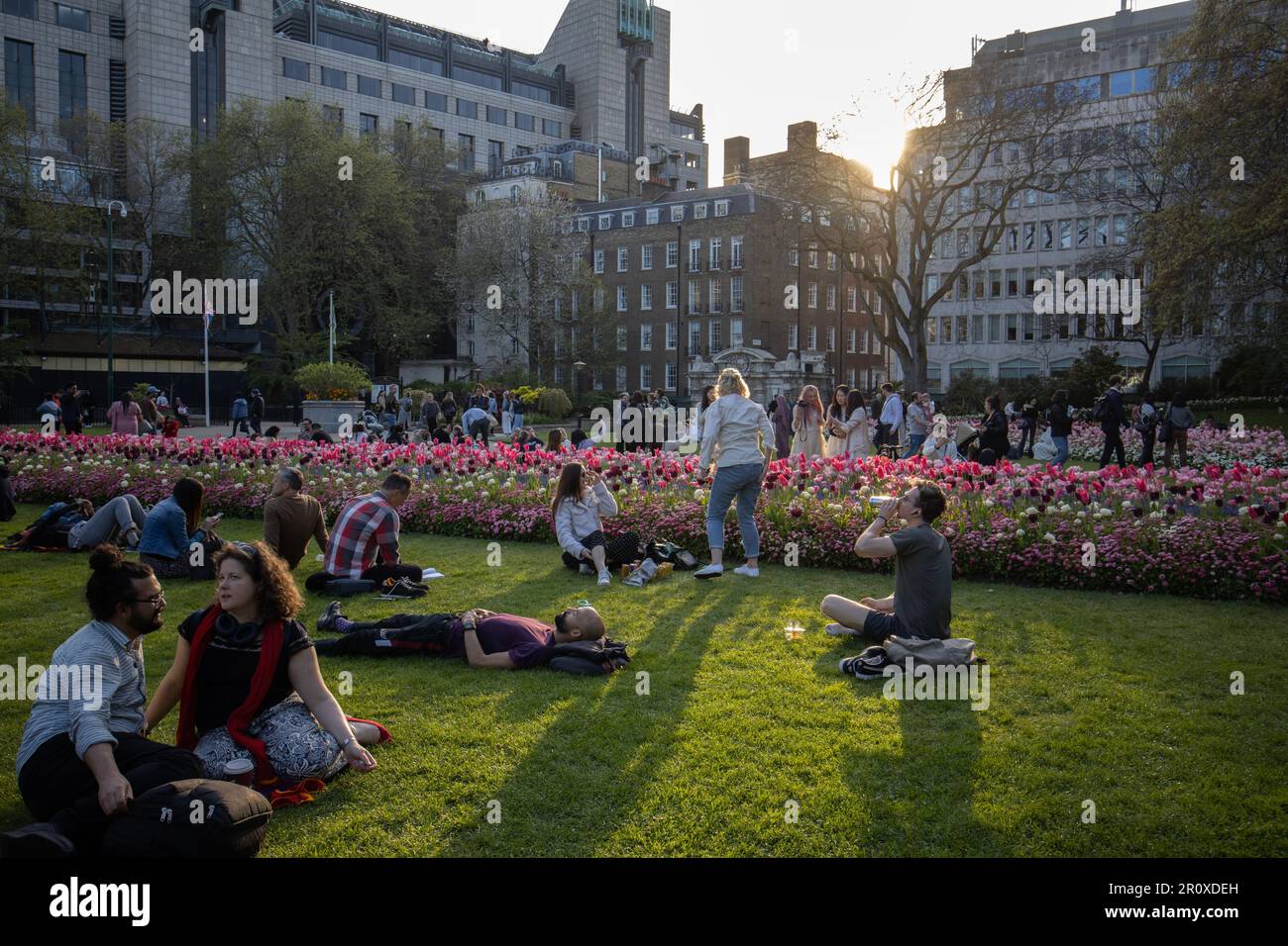 Tourists enjoying the Coronation flowers and evening sunshine at ...