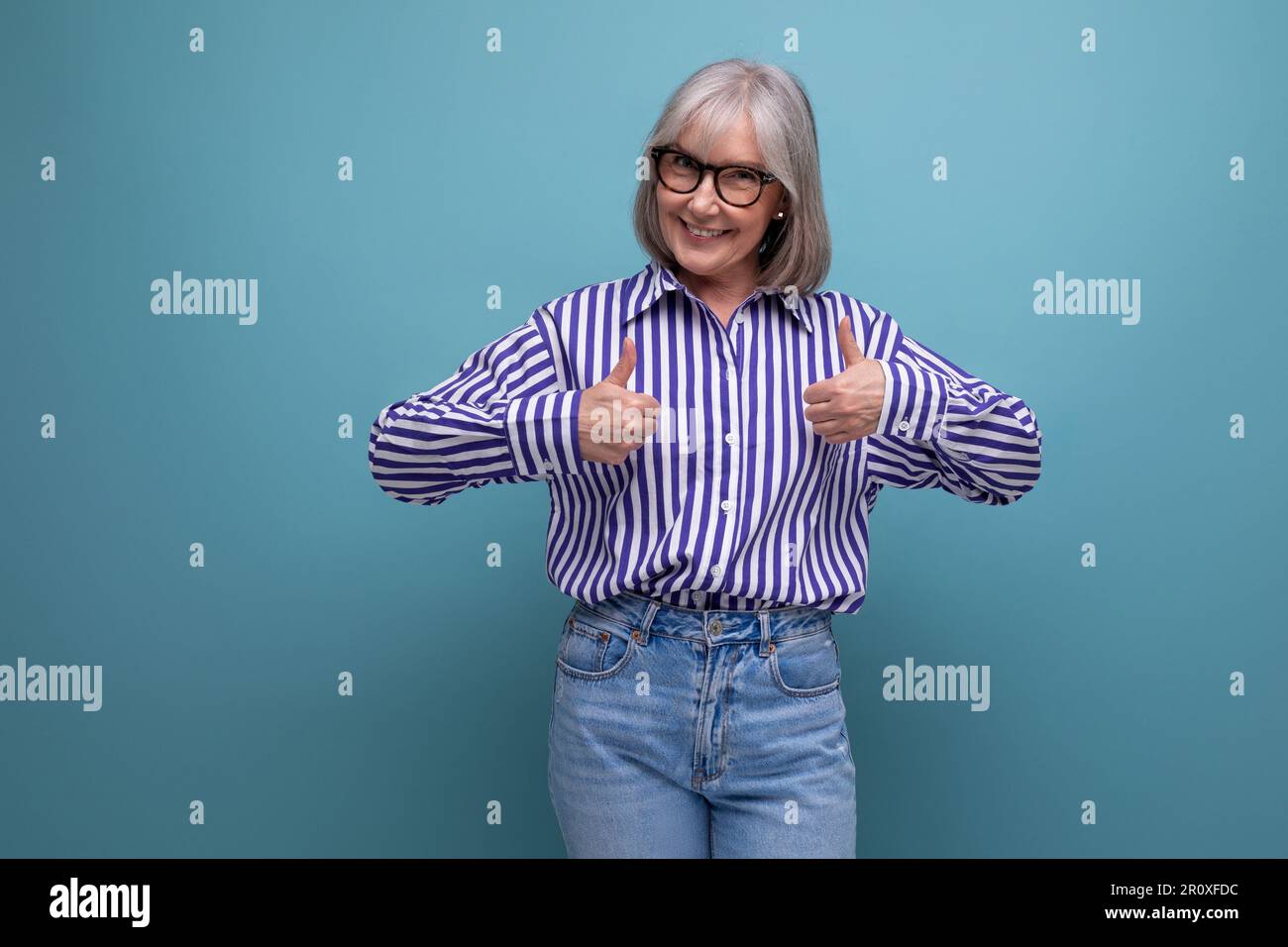 approvingly smiling 60s woman with gray hair in a stylish look on a ...