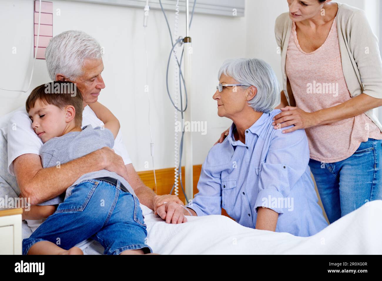 Healing hug for granddad. a sick man in a hospital bed getting a hug ...