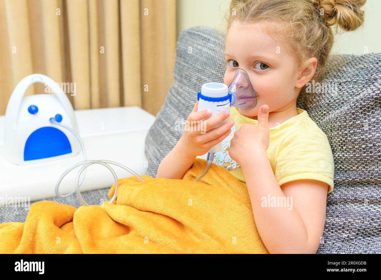 The child shows the OK sign when breathing through the inhaler Stock ...