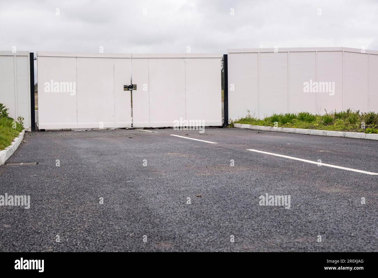 Closed and locked white wood gates at the entrance to a construction ...