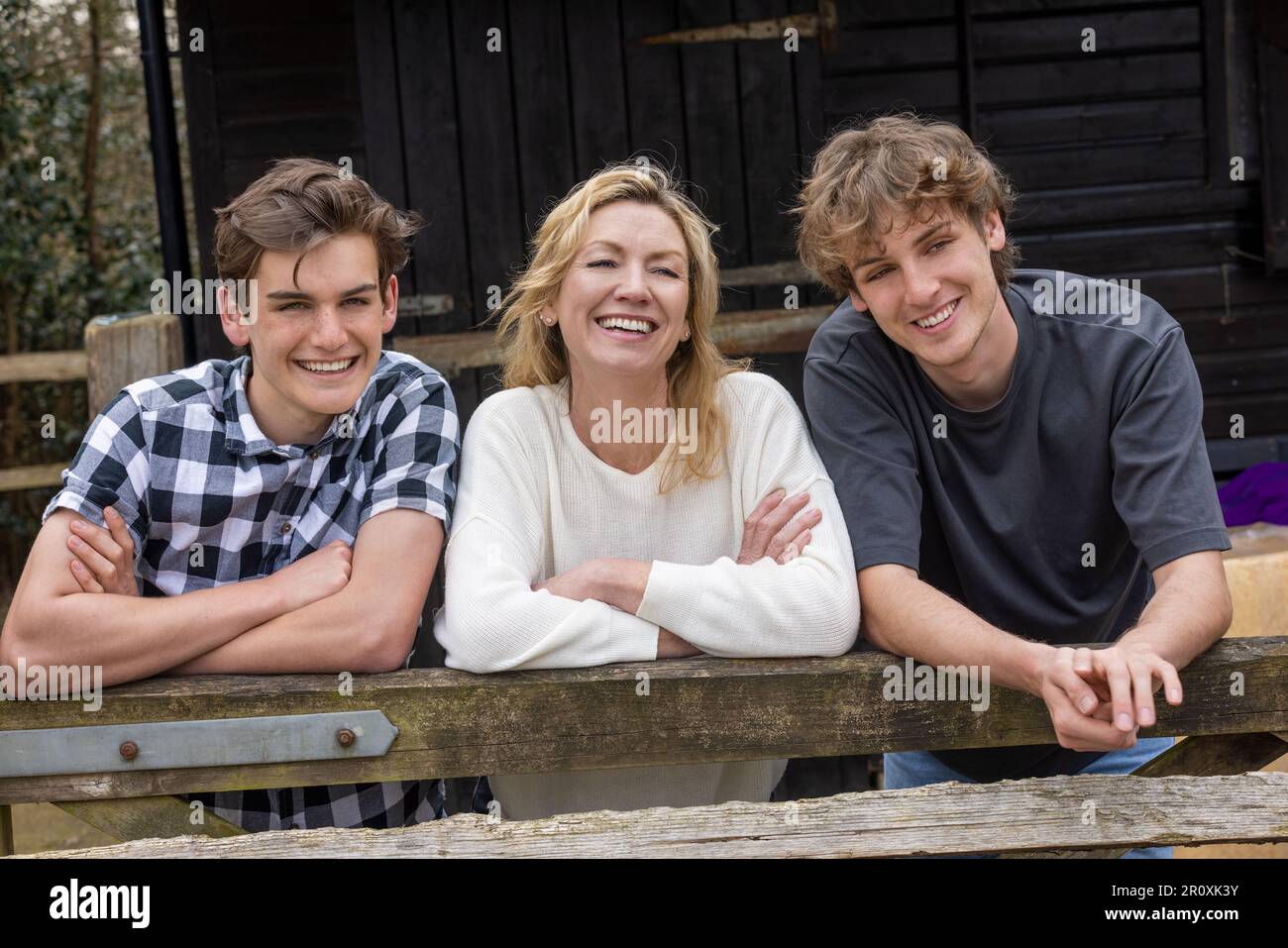 Family of mother and two teenage young men adult sons boys outside ...