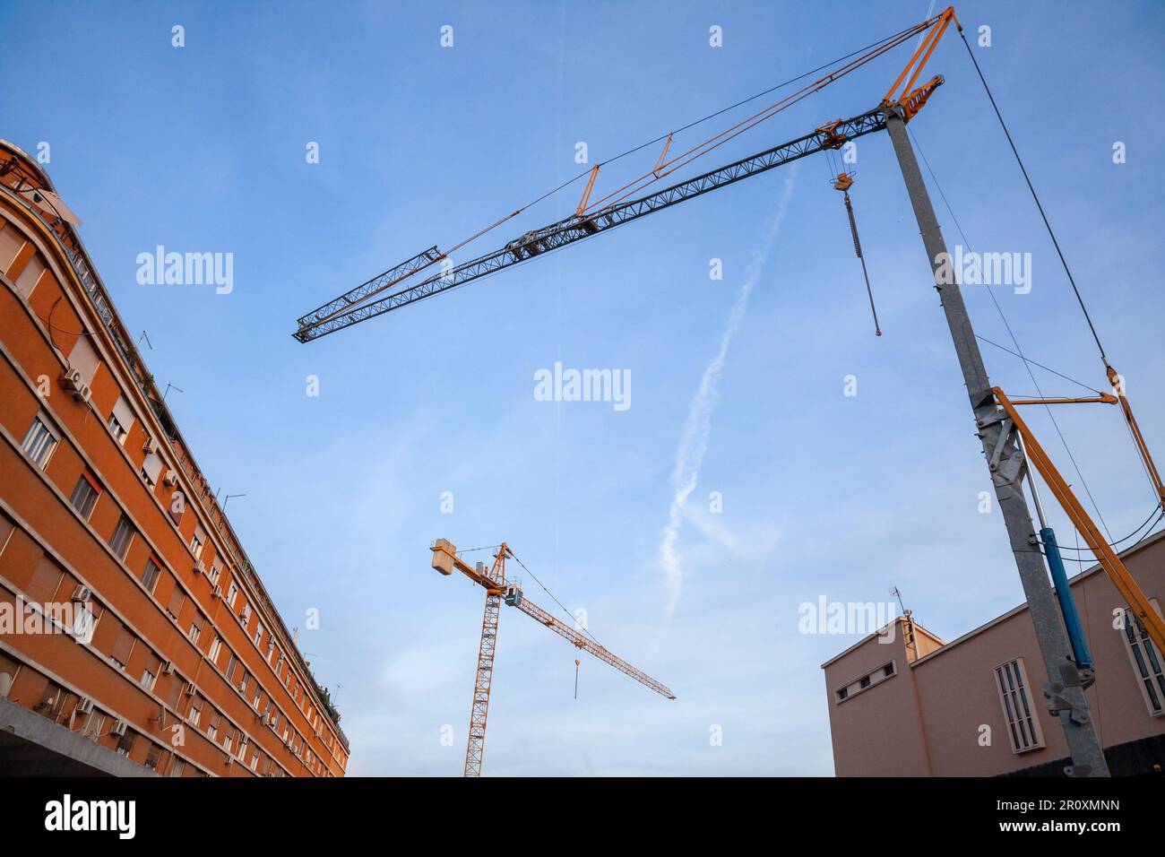 Picture of cranes, made of steel, red color, taken from afar in an ...