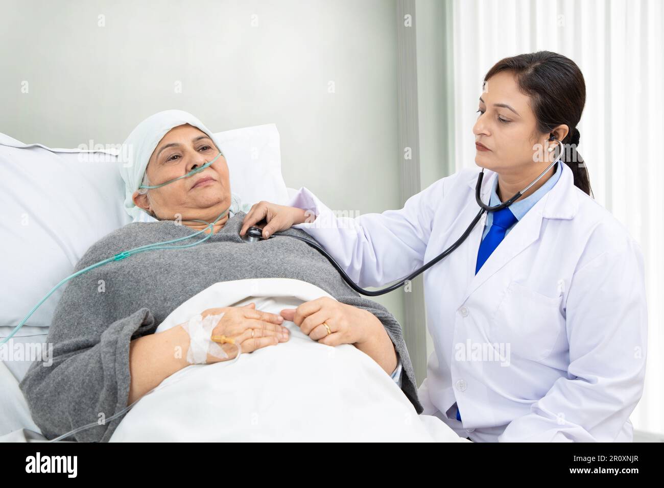 Indian doctor check heat beat of senior cancer patient undergoing ...
