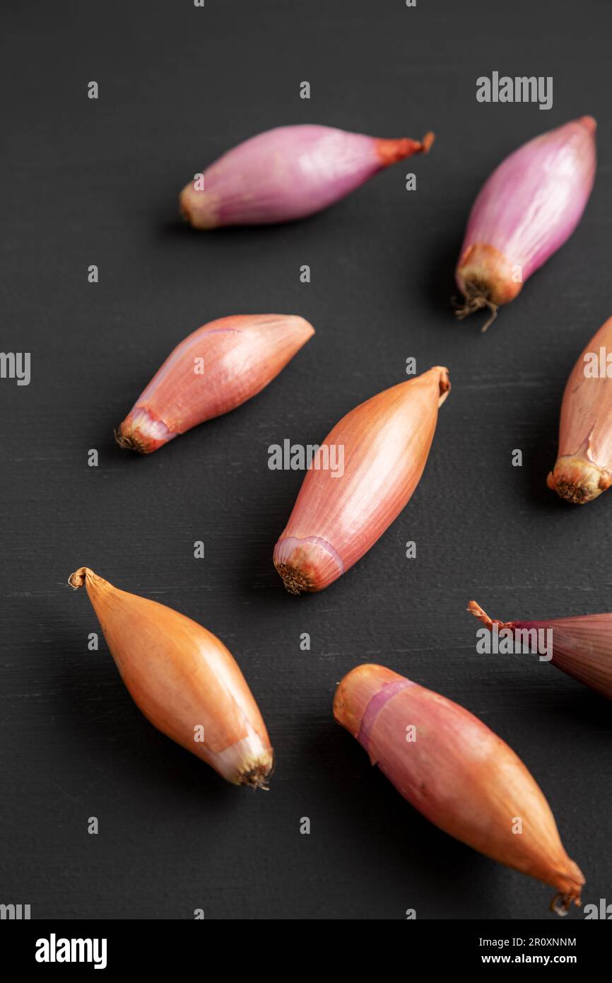 Raw Organic Shallots on a Black surface, side view Stock Photo - Alamy