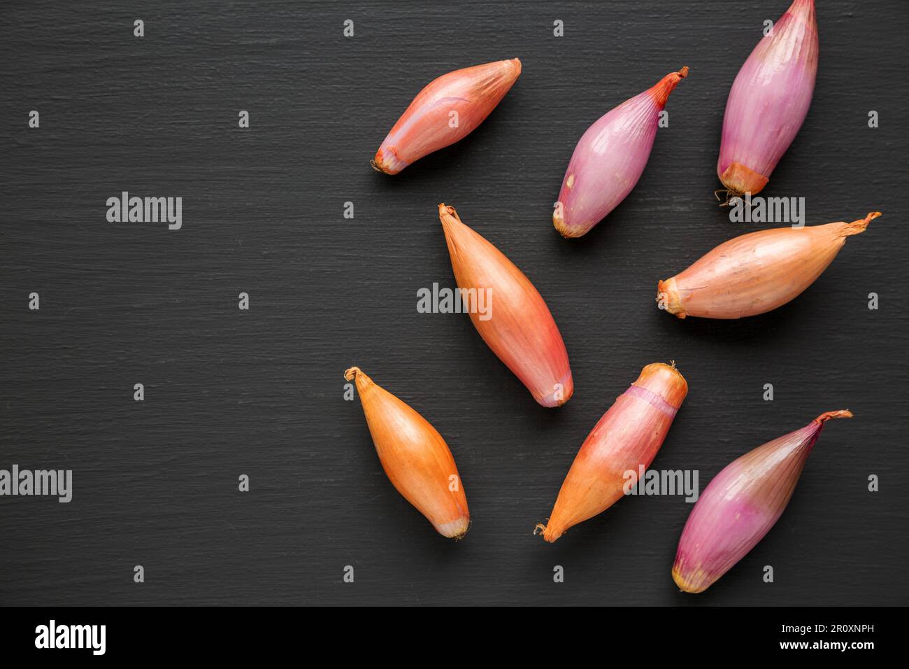 Raw Organic Shallots on a Black background, top view. Overhead, from ...