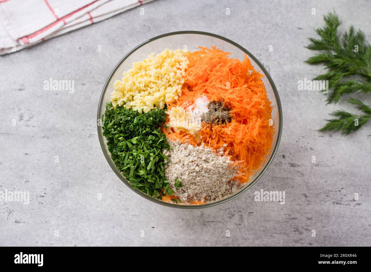Glass bowl with ingredients for vegan cutlets, burgers: millet, carrots ...