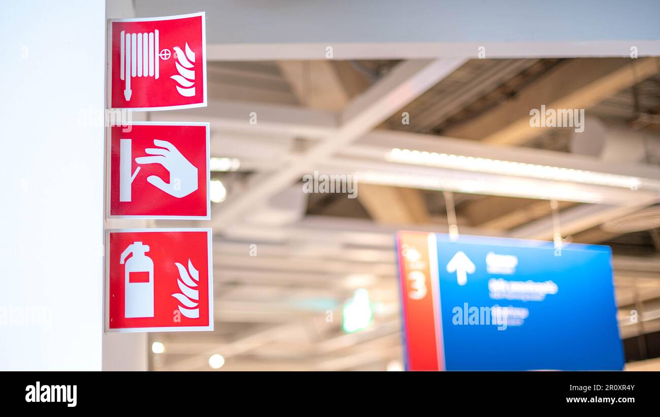 A red emergency fire exit direction plate that installed on the white ...