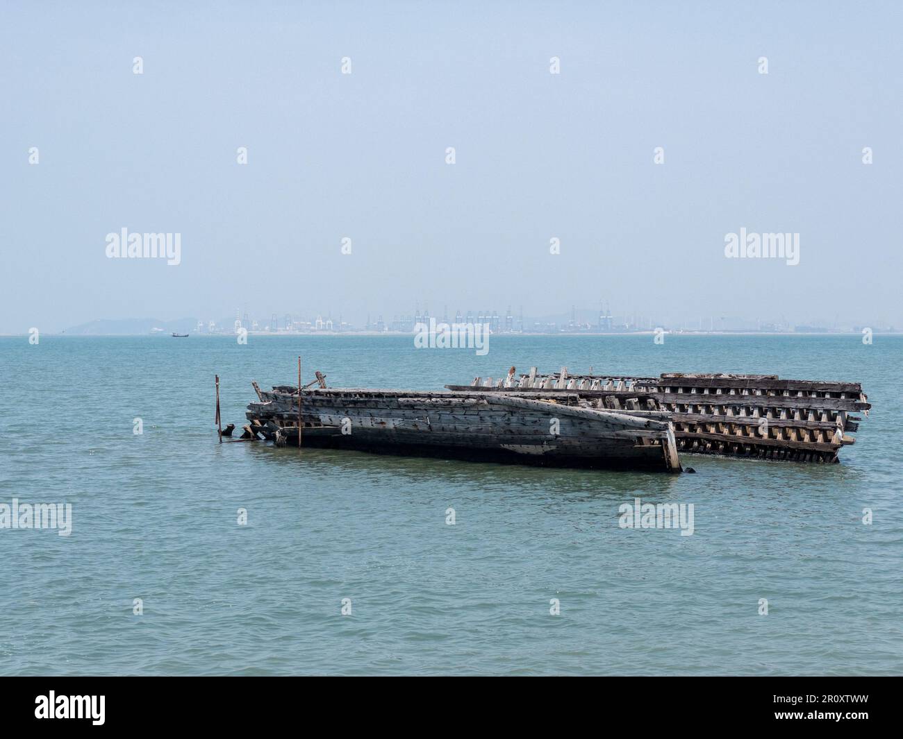 An abandoned wooden ship ran aground on the shore near the harbor ...