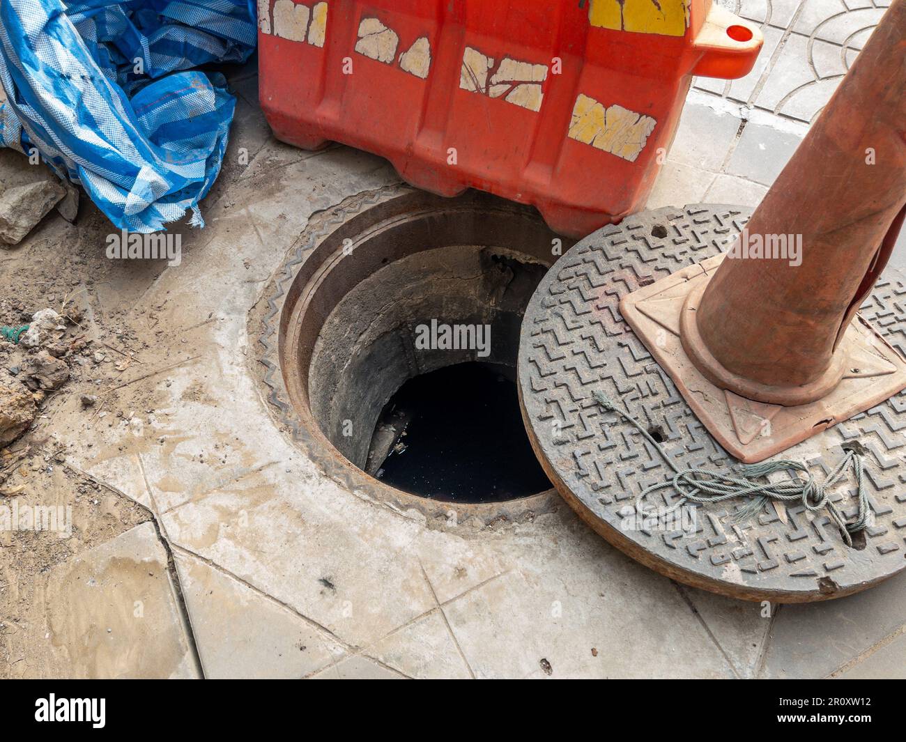 The manhole cover was opened for maintenance time near the sidewalk in ...