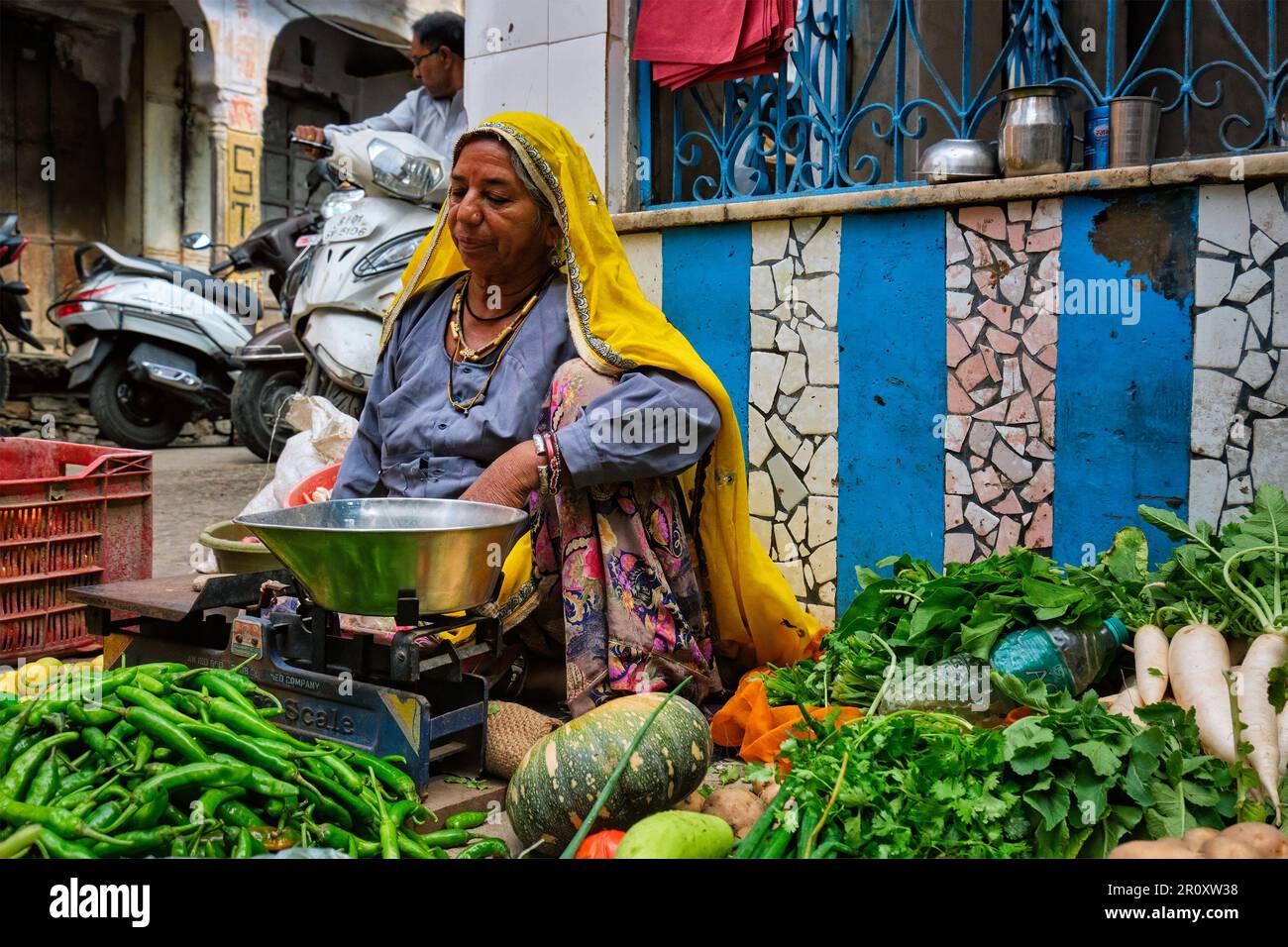 Woman street vegetable vendor selling vegetables in the street of Pushkar, Rajasthan, India ...