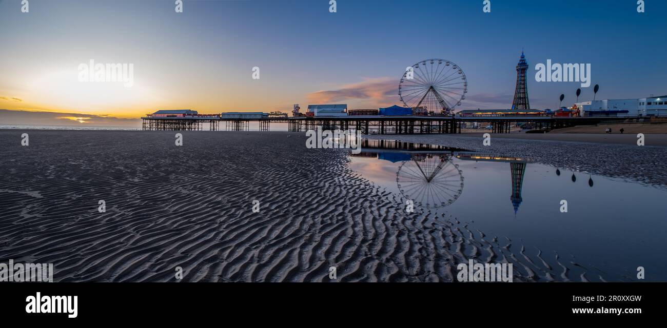 A panoramic view of Blackpool beach at sunset, featuring reflections of ...