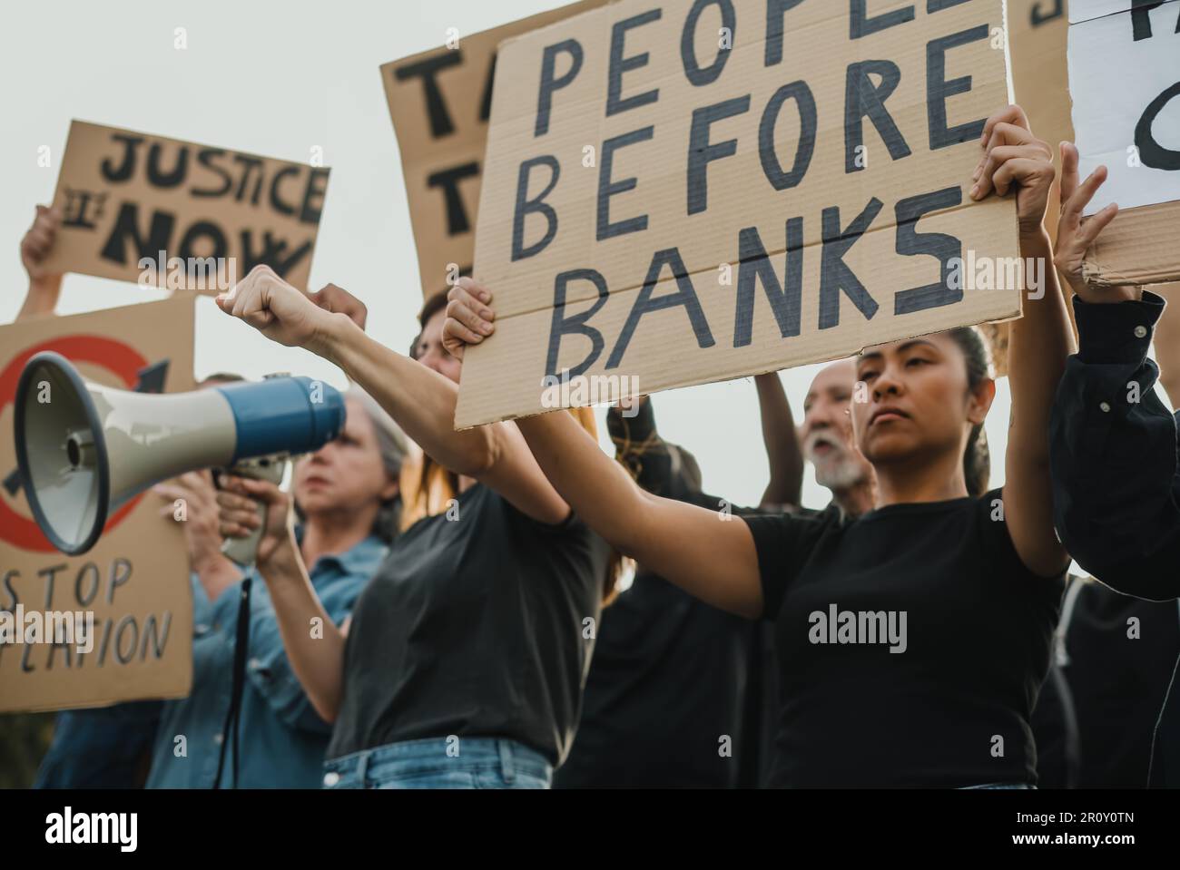 From below crowd of diverse protesters in casual clothes standing with ...