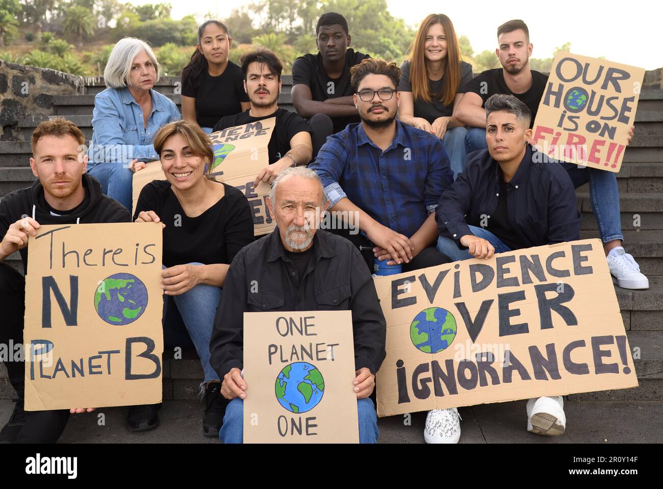 Group of diverse protesters with placards on topic of environmental ...
