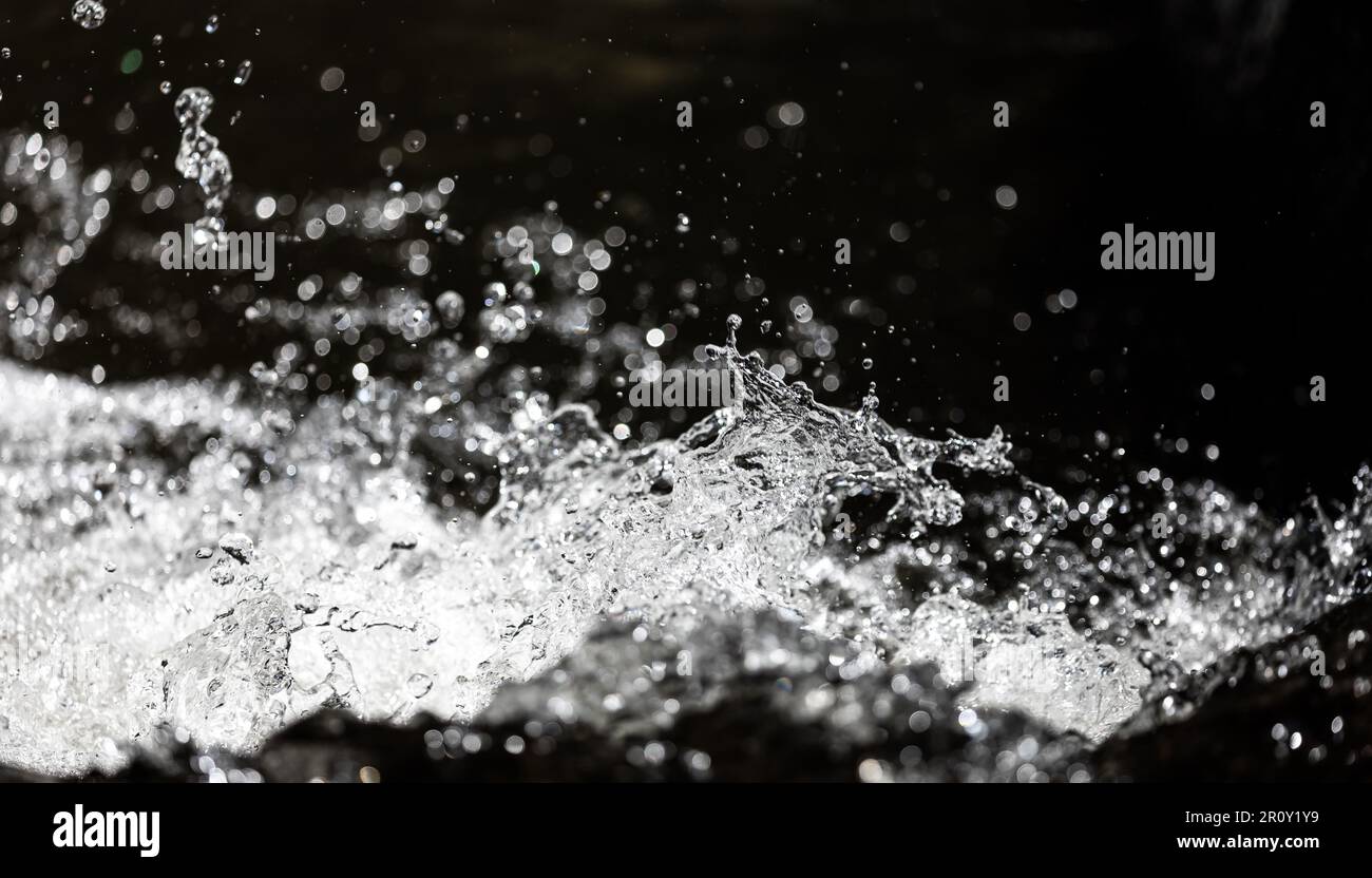 Close focus on fast moving water in river with stopped motion technique ...