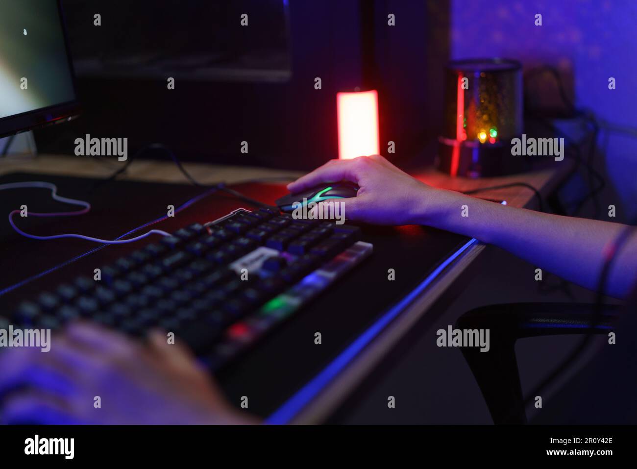 Female cyber hacker gamer using keyboard and mouse to playing games or ...