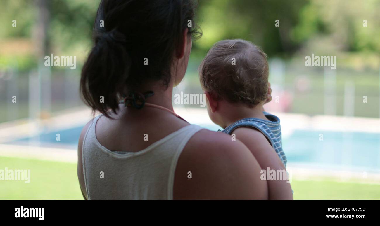 Candid mother holding baby outside, mom calming and consoling infant ...