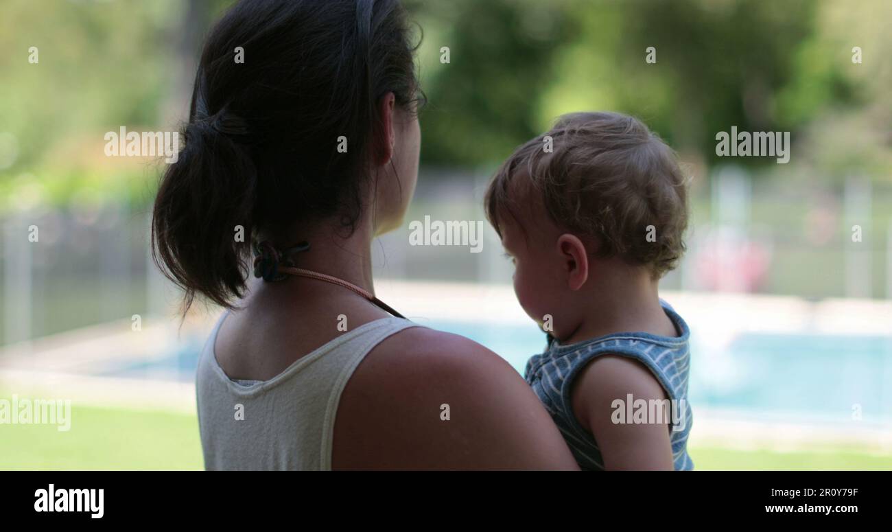 Candid mother holding baby outside, mom calming and consoling infant ...