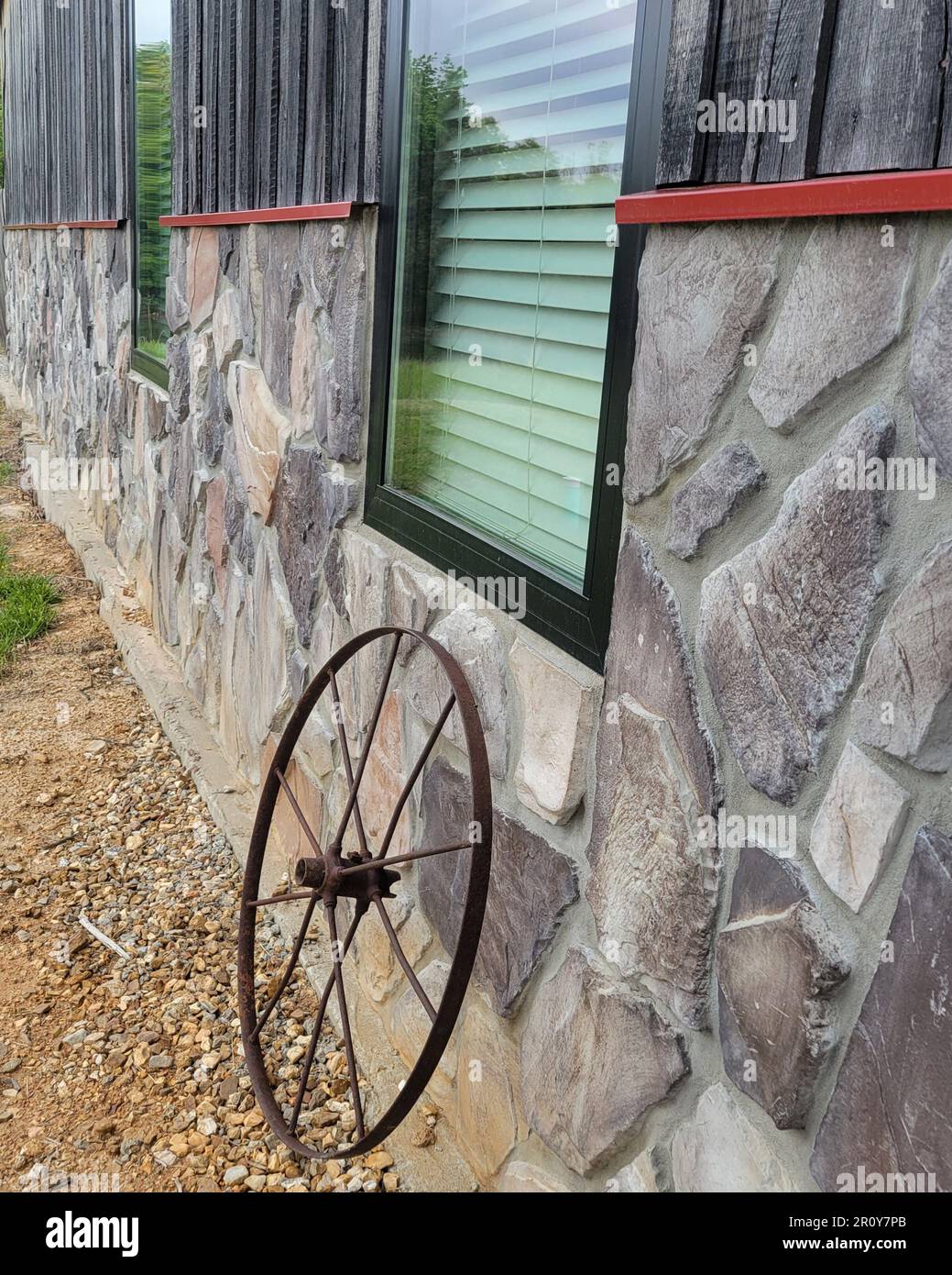 A view down an exterior wall of a stone and wooden building, complete ...