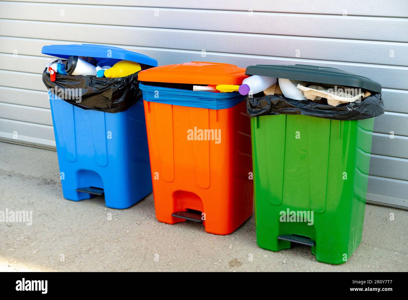 Three trash containers full of garbage near the building Stock Photo ...