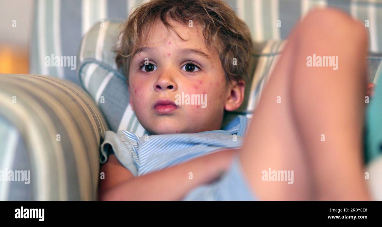 Adorable child boy watching TV at night, candid kid staring at screen ...