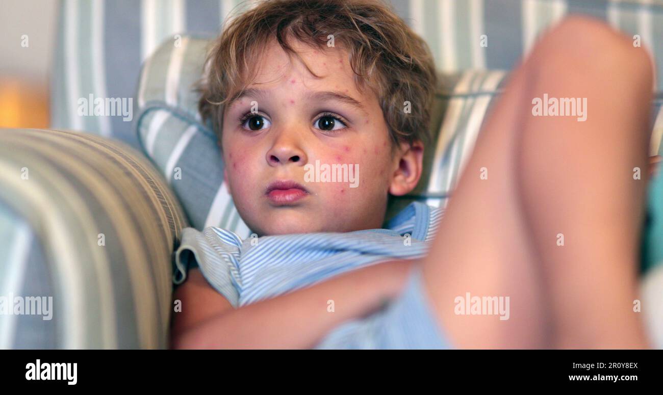 Adorable child boy watching TV at night, candid kid staring at screen ...